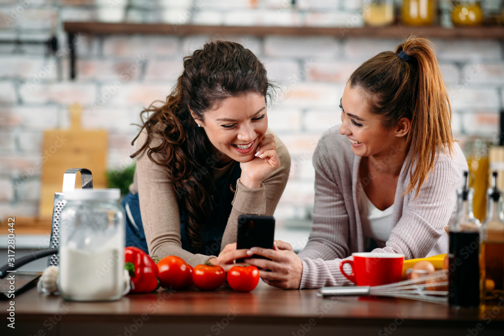 Sisters cooking together. Two friends having fun in kitchen. Stock ...