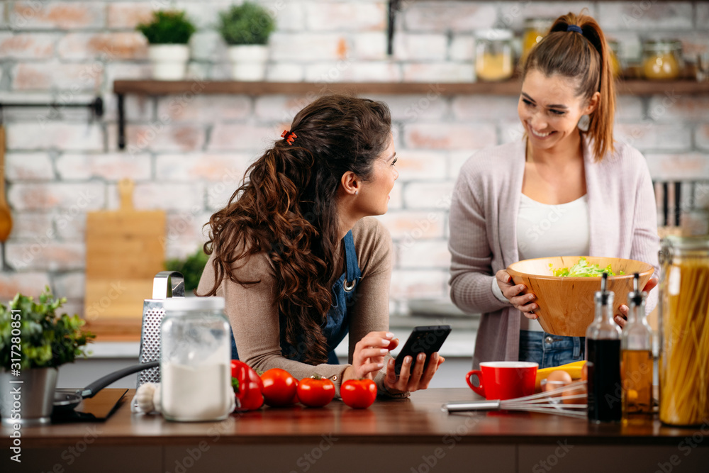 Sisters cooking together. Two friends having fun in kitchen. Stock ...