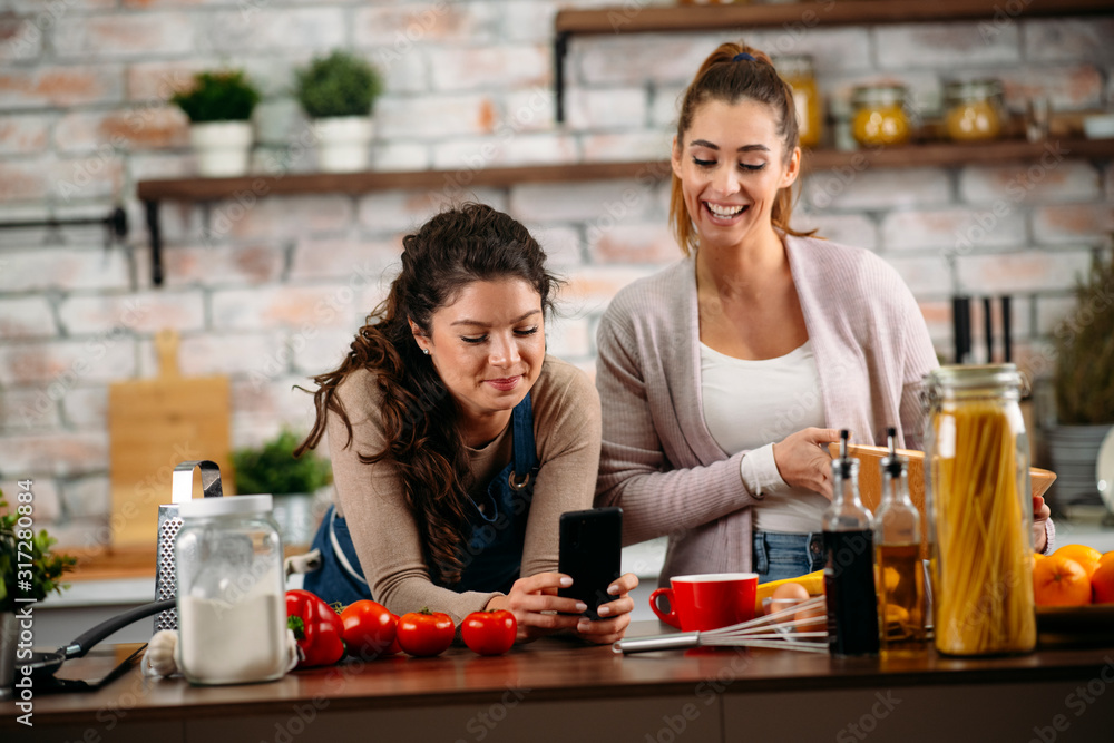 Sisters cooking together. Two friends having fun in kitchen. Stock ...