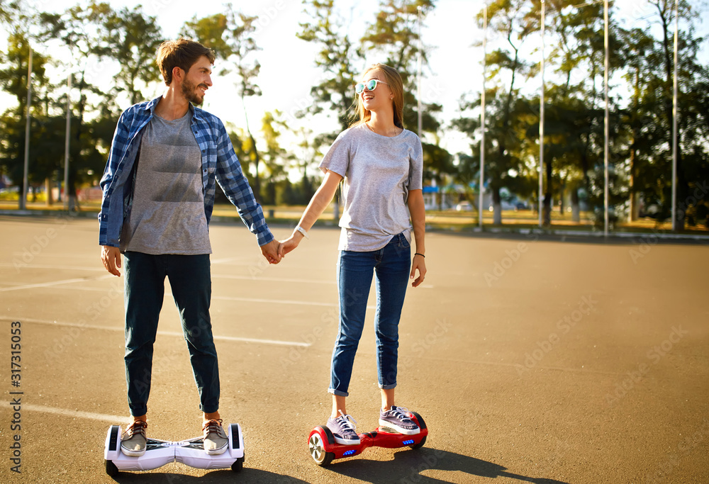 Happy man and woman riding on the Hoverboard for relaxing time together ...
