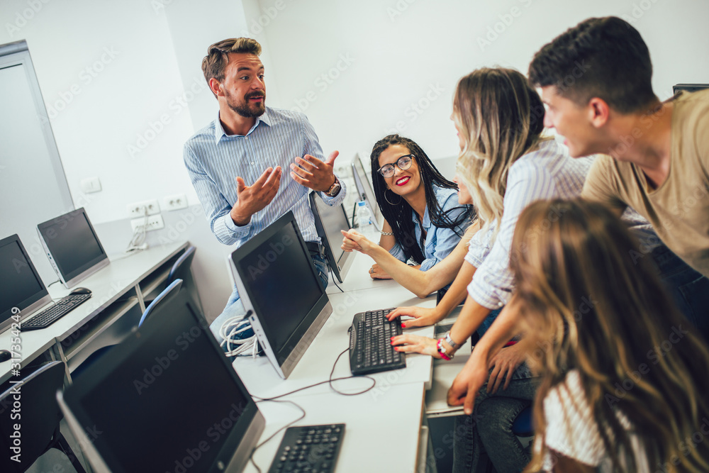 College students sitting in a classroom, using computers during class ...