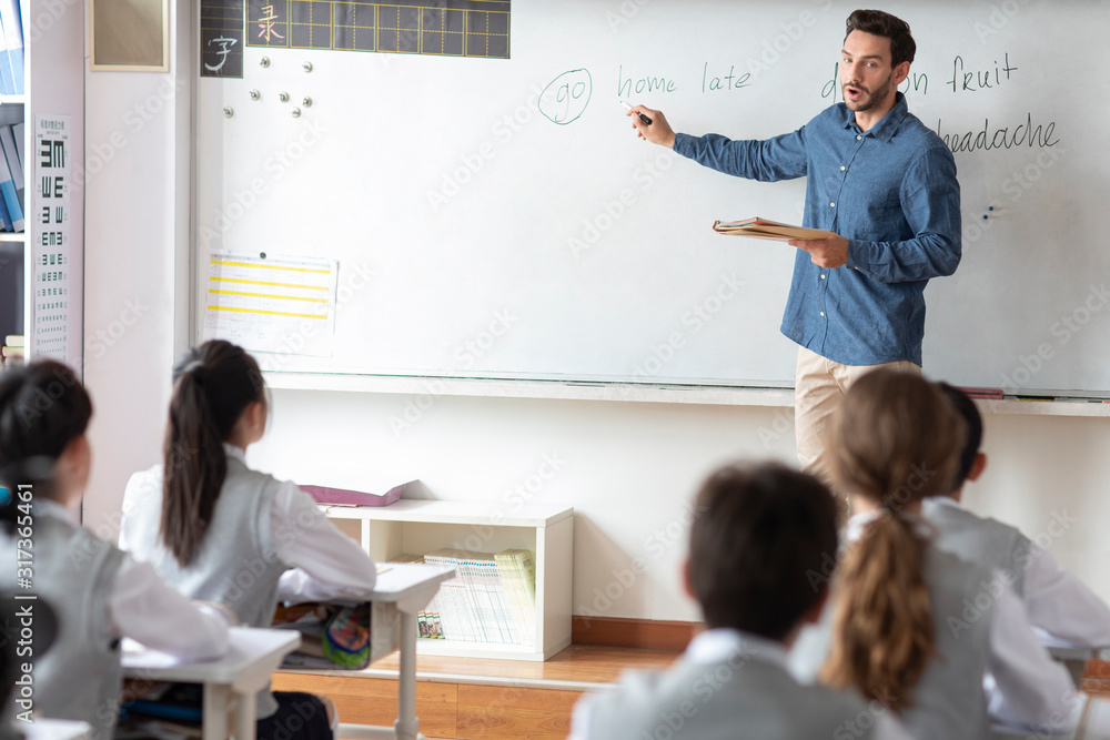 Young teacher teaching a class Stock Photo | Adobe Stock