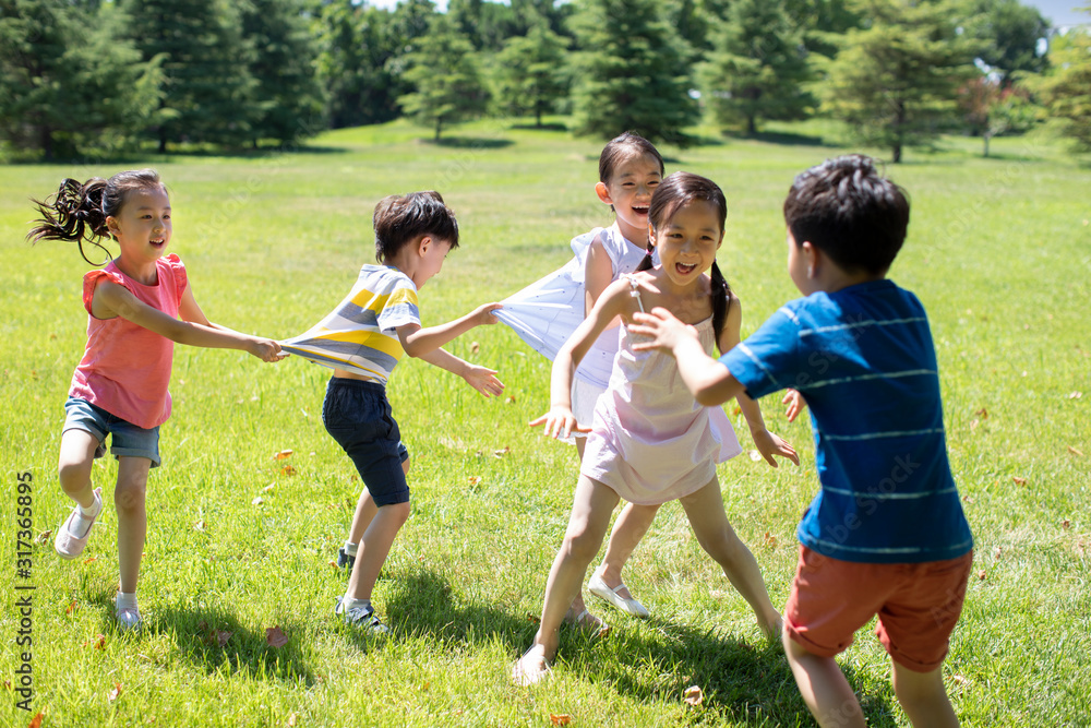 Happy children playing games on meadow Stock Photo | Adobe Stock