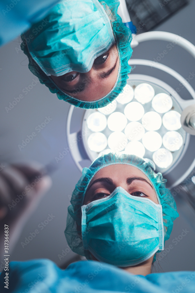 From below female surgeons in medical uniform using professional tools ...