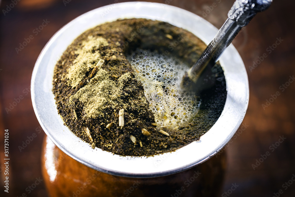 Yerba mate tea in calabash on wooden table. Traditional Argentine ...