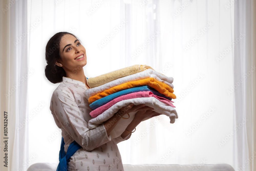 Portrait of a single woman carrying folded clothes in her hand. Stock ...