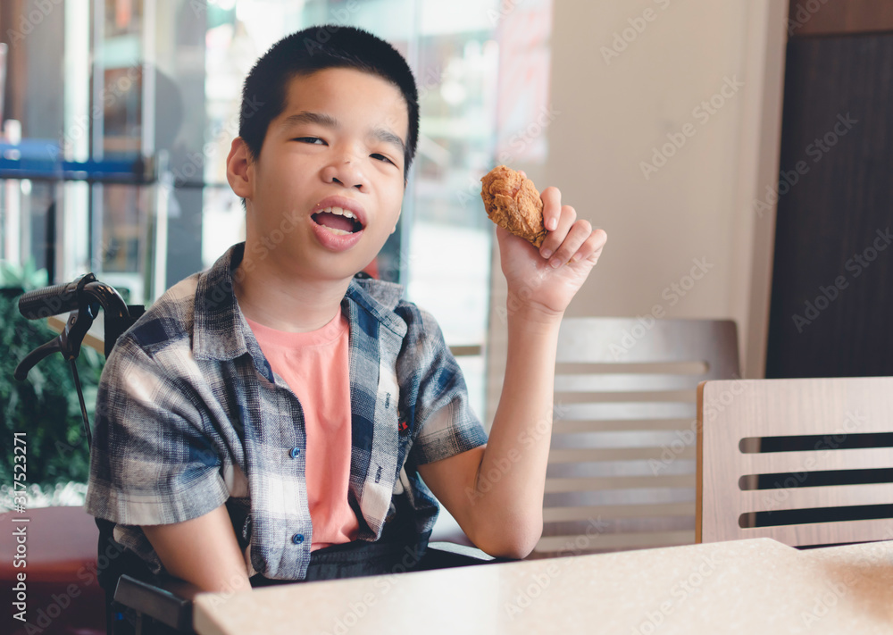 Asian disabled child on wheelchair eating Chicken Drumstick by ...