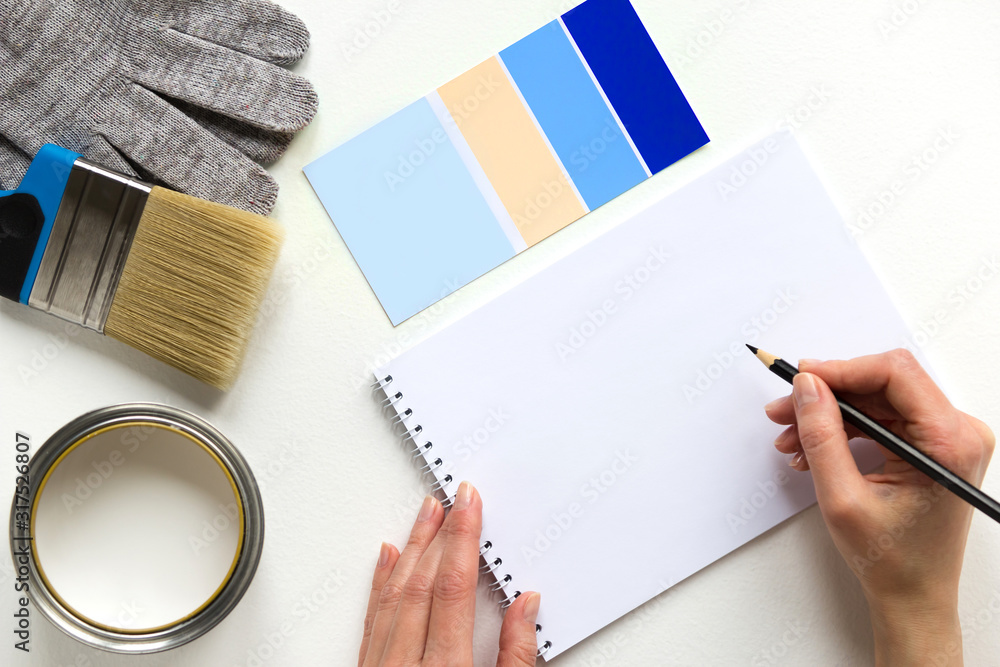 Paint color chart sample swatches, gloves, notebook and woman hand with ...