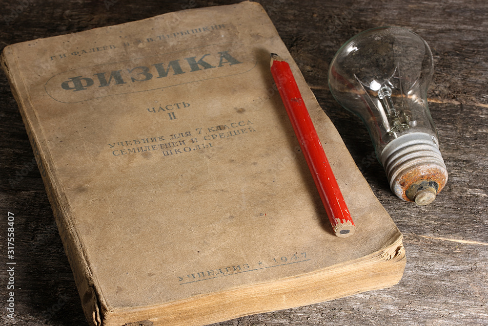 Light bulb on a 20th century textbook. Physics textbook for 7th grade ...