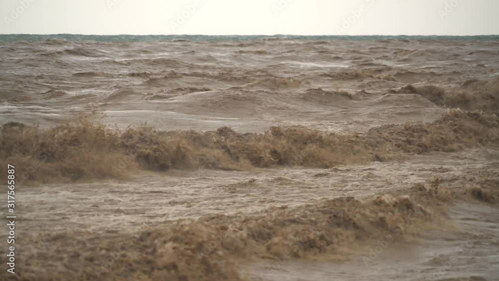 Brown muddy sea waves. Flood waters join reach the sea. Creates strong ...