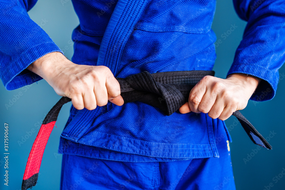 Close up on midsection of the bjj brazilian jiu jitsu black belt hands ...