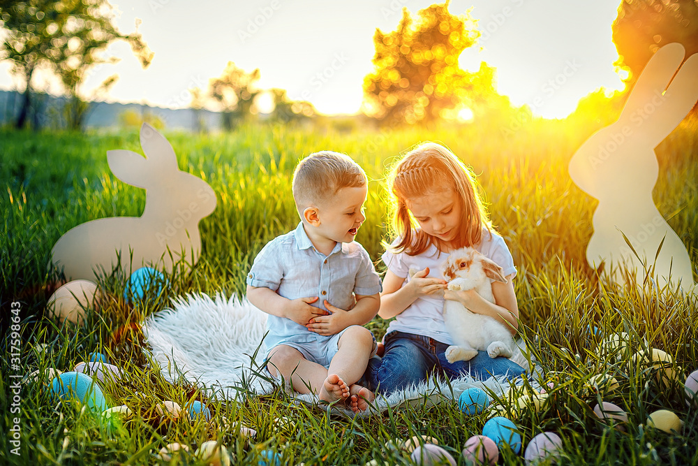 Little girl and boy play with the rabbit. happy little girl holding ...