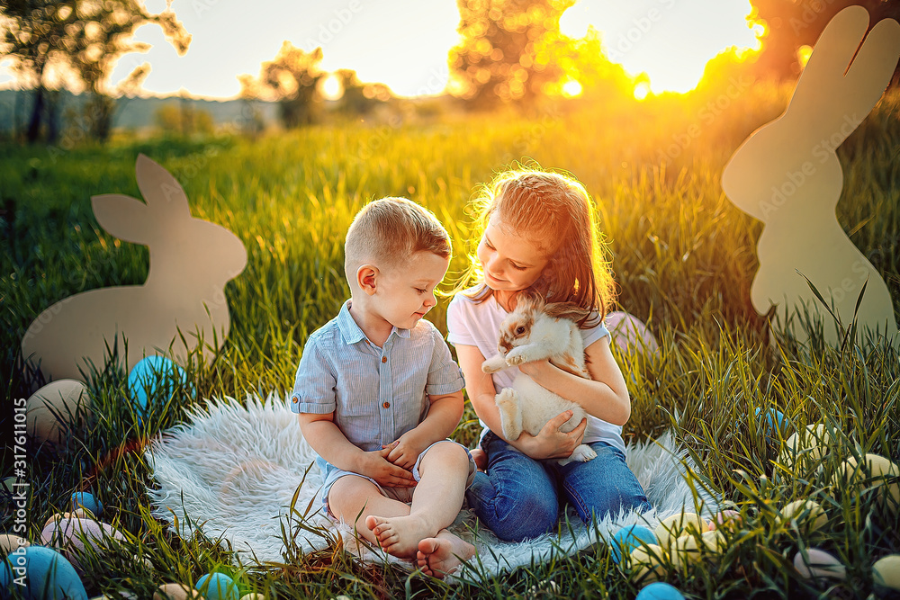 Little girl and boy play with the rabbit. happy little girl holding ...