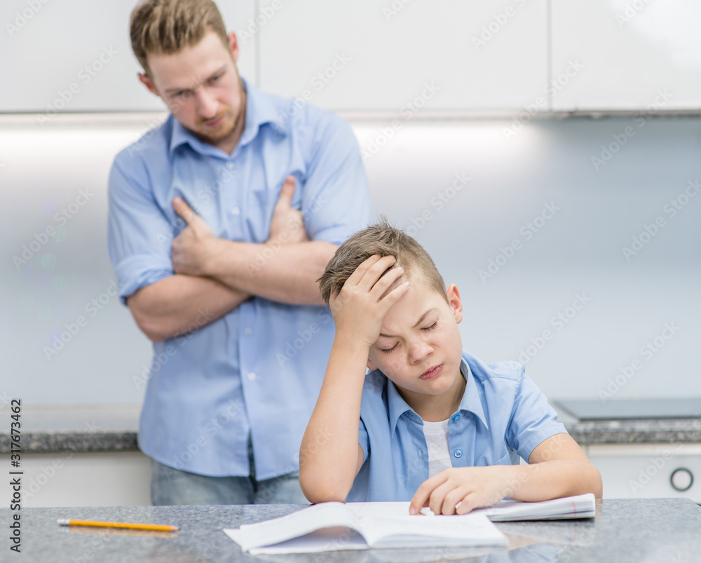 Angry father controls the execution of the son of homework Stock Photo ...