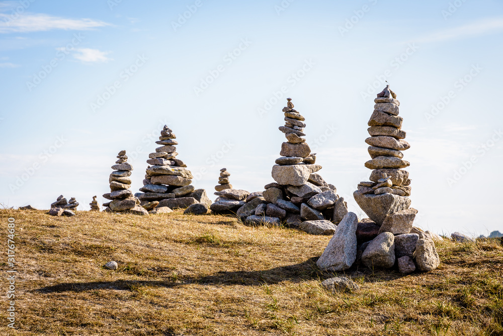 Many man-made granite stone stacks (called cairns) on the coastal path ...