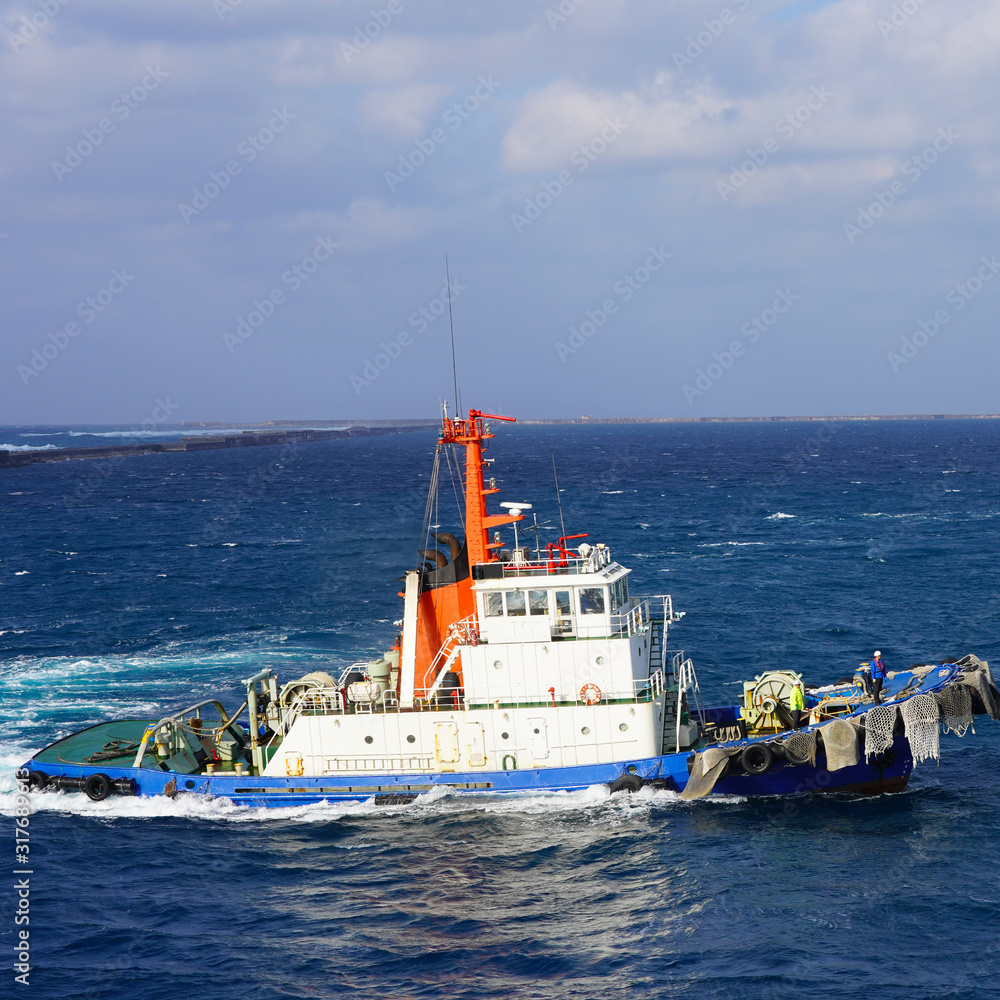 bright sea tug in the port of the Japanese city of Naha. Powerful ...