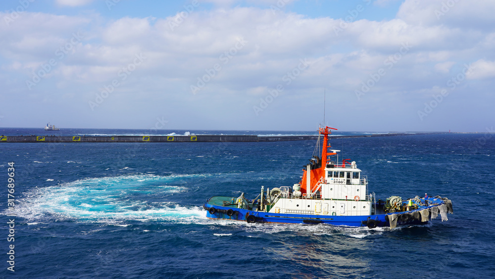 bright sea tug in the port of the Japanese city of Naha. Powerful ...