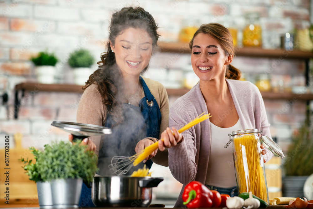 Two friends having fun in kitchen. Sisters cooking together. Stock ...