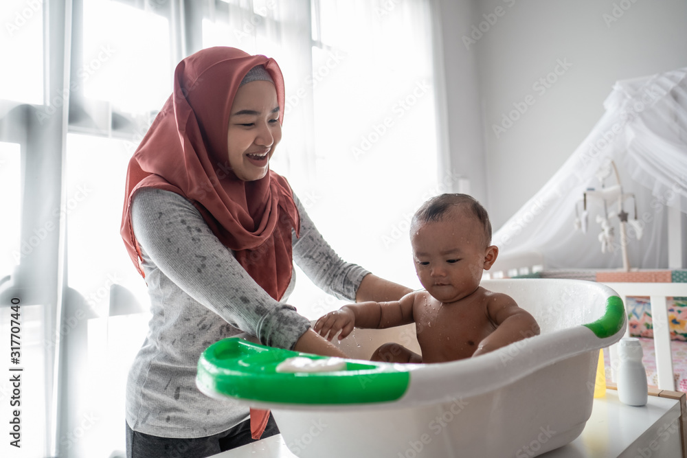 muslim Mother washing little boy in bathtub. Smiling toddler in ...