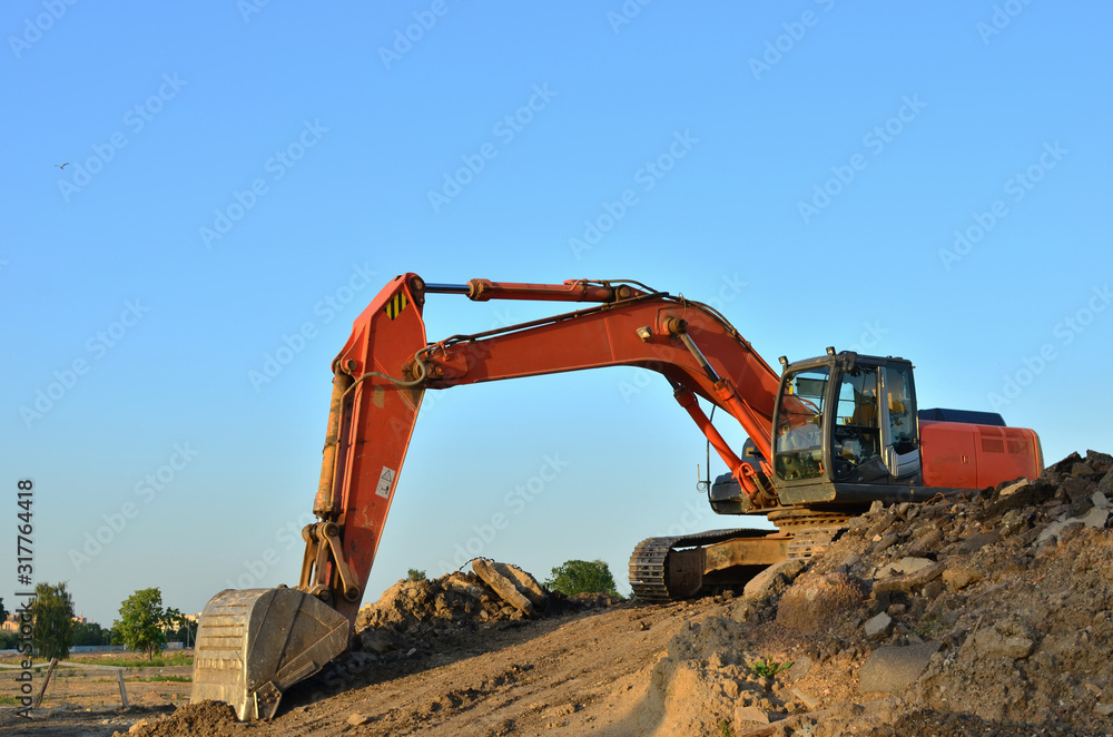 Excavator at a construction site during earthworks and laying of ...