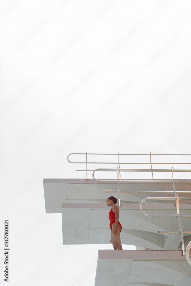 Young woman in swimsuit standing on diving board Stock Photo | Adobe Stock