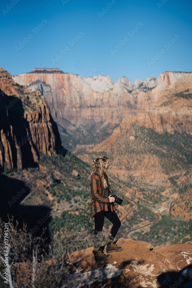 Young girl posing with a camera with Zion National park as background ...
