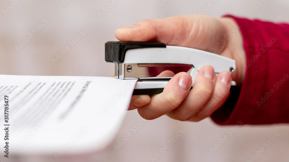 An office worker attaches documents using a stapler_ Stock Photo ...