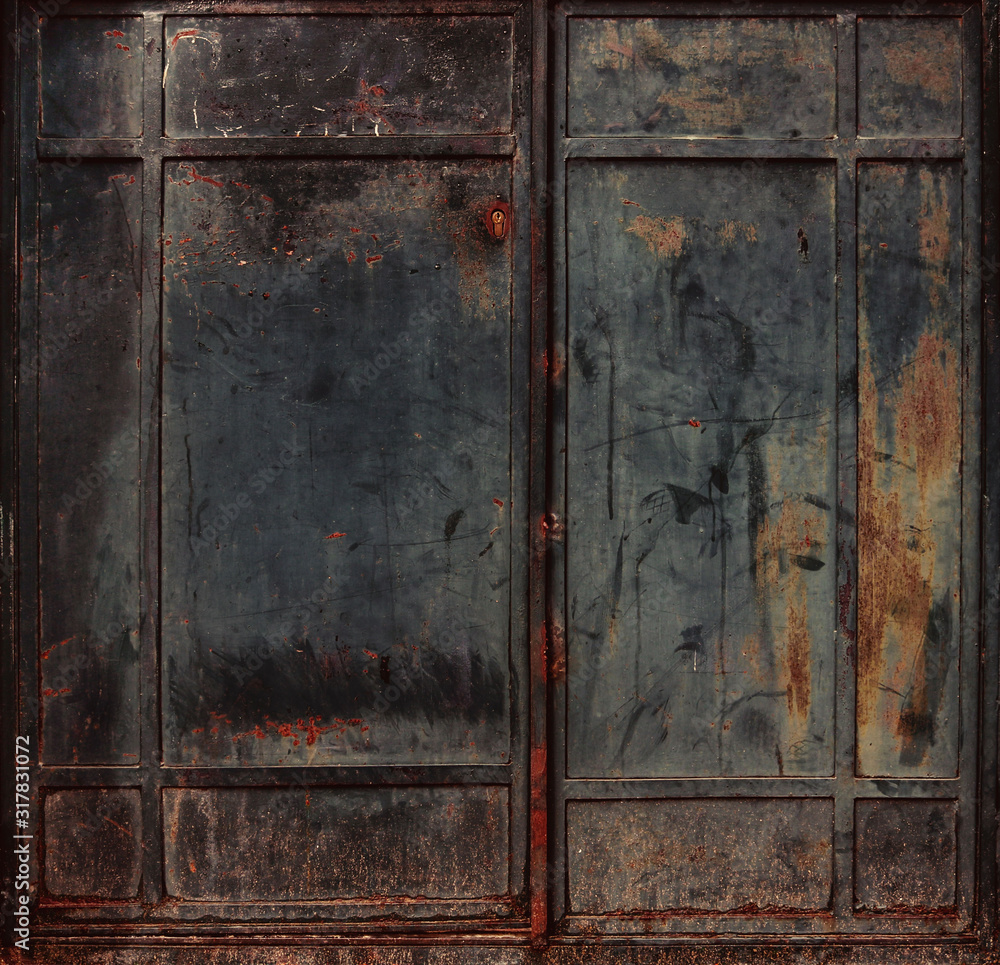 Dirty and rusty black metallic doors of an abandoned factory looking ...