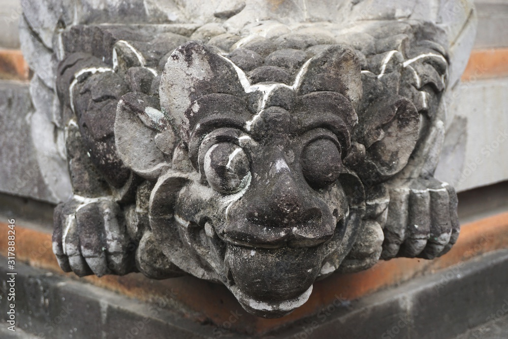 Smiling stone gargoyle at a temple in Bali Indonesia Stock Photo ...