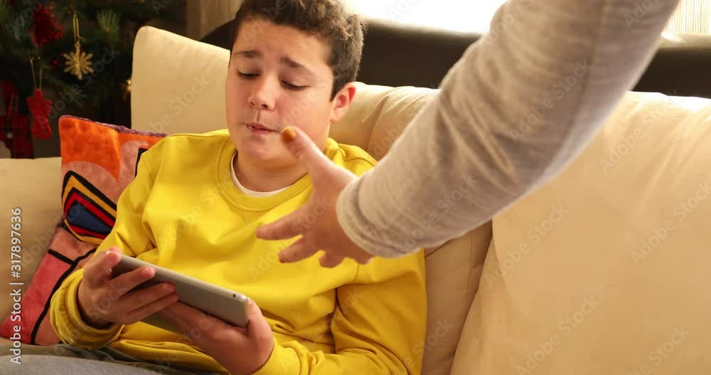 Mother hand take away tablet computer but smart young boy taking smart ...
