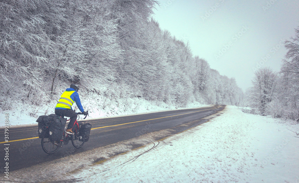 Male man in black and bue is cycling on fully loaded touring bicycle in ...