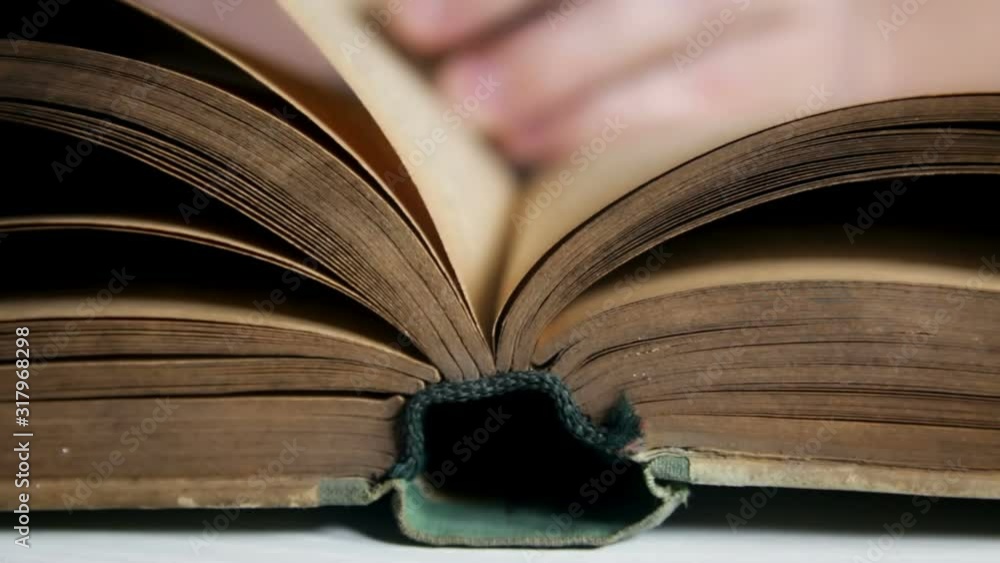 Man leafing through a thick old book Stock Video | Adobe Stock