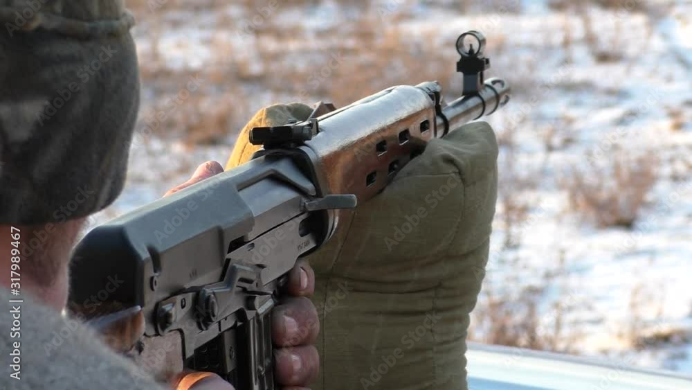 A sniper shoots a Tiger carbine in winter. Shooting at a target through ...