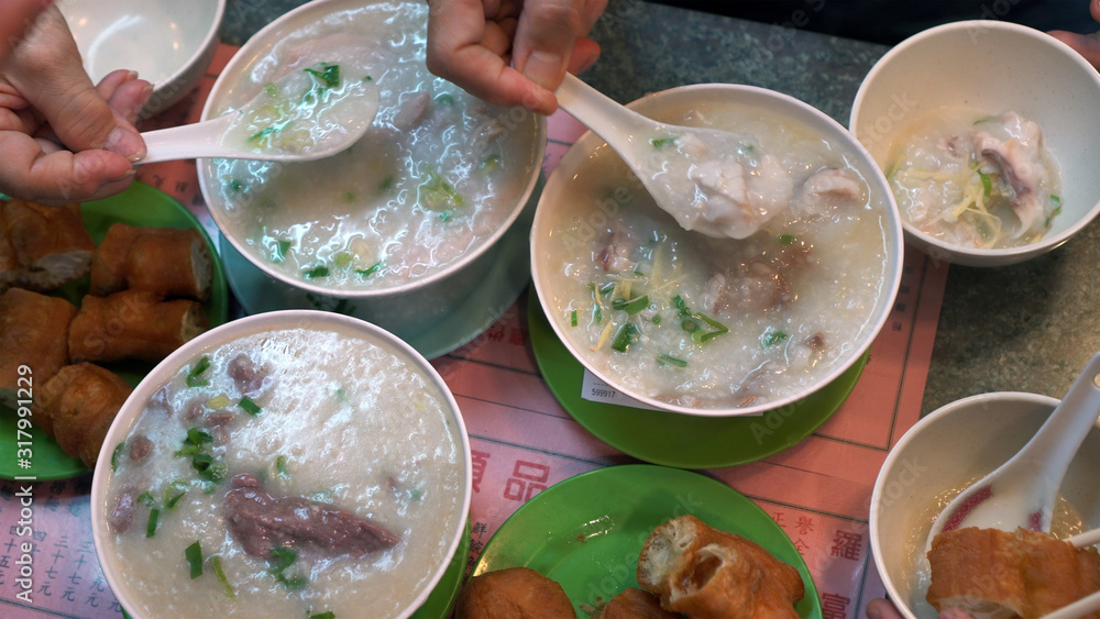 Hands eating congee boil rice and fried dough Hong Kong Cantonese ...