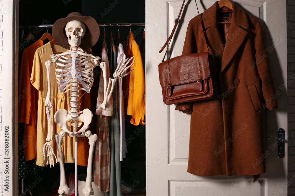 Artificial human skeleton model among clothes in wardrobe Stock Photo ...