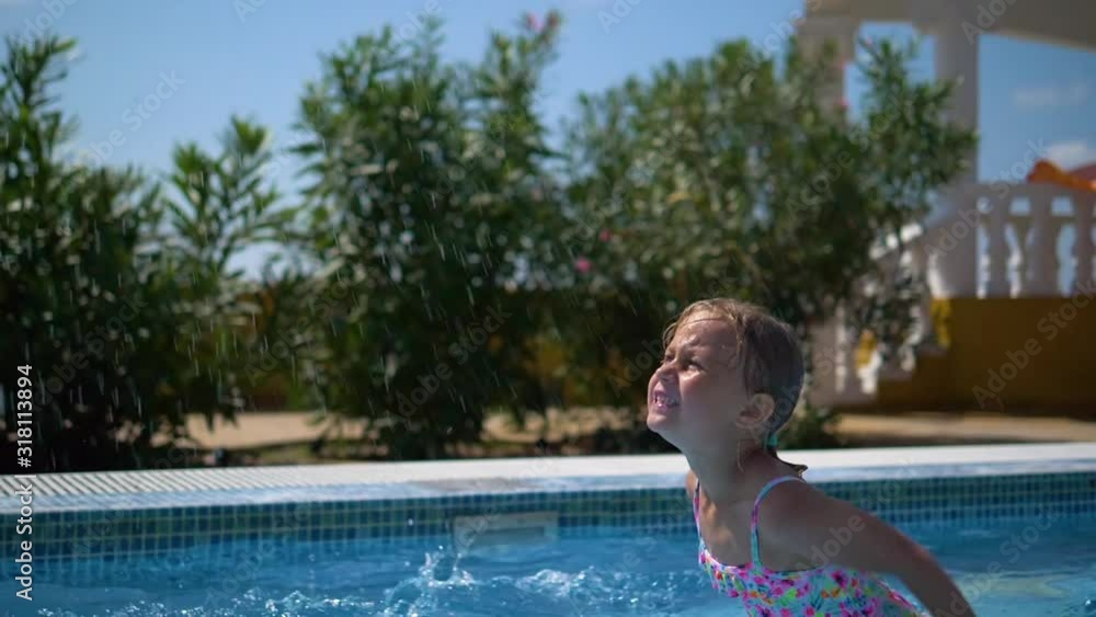Vidéo Stock Little girl splashing in the swimming pool Slow motion ...