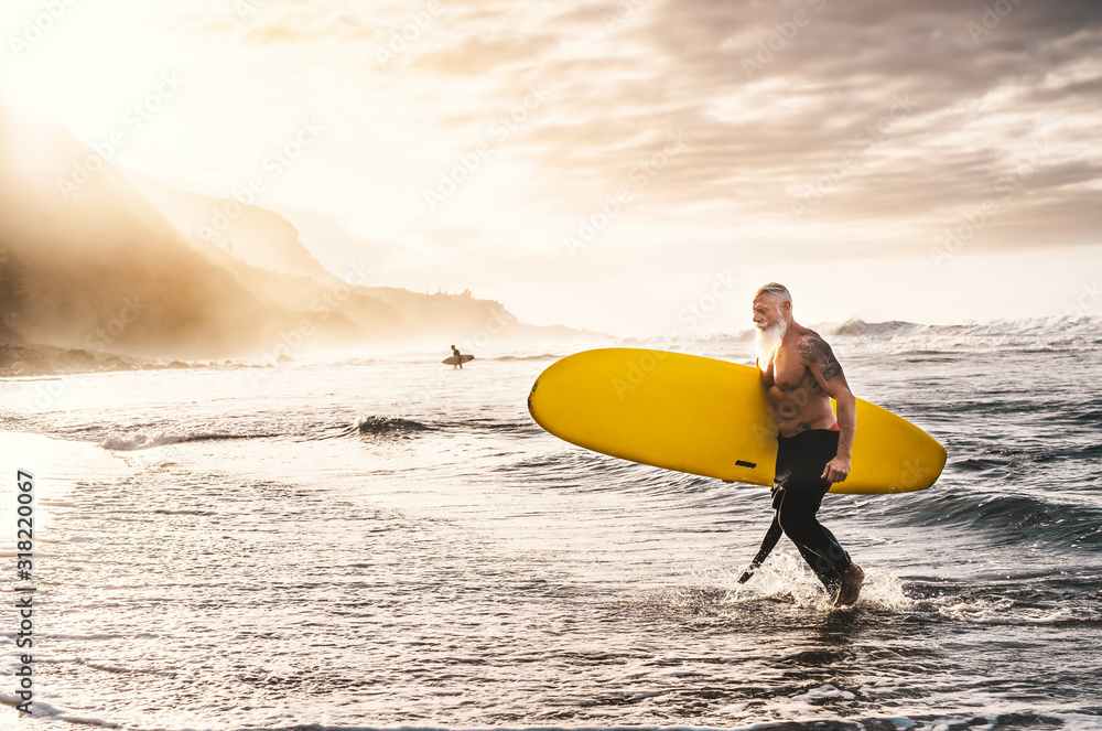 Happy fit senior surfing on sunset time - Sporty mature man having fun ...