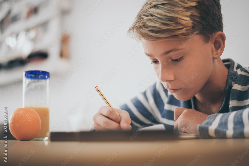 Student drawing with pencil on the notebook. Boy doing homework writing ...