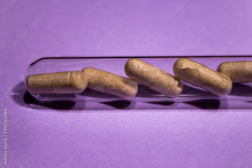 Pills, antibiotics, natural preparations half in a glass test tube on a ...