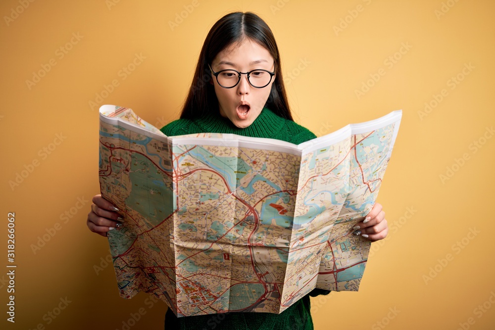 Young asian turist woman looking at city tourist map on a trip over ...