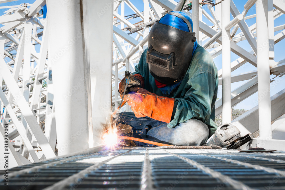 Industrial welder welding fabricated metal truss structure assembly on ...