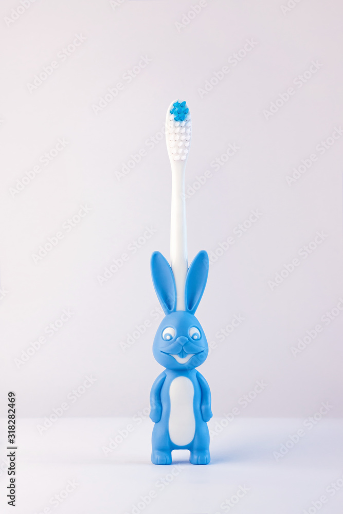 Children's toothbrush in a form of cute blue bunny on white background ...
