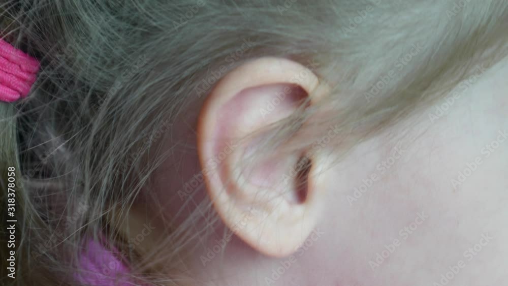Vidéo Stock Little girl wiggles her ear in close-up. Blonde girl's ear ...