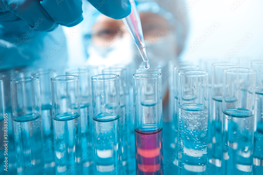 A drop is dripping from a pipette into a test tube. Laboratory research ...