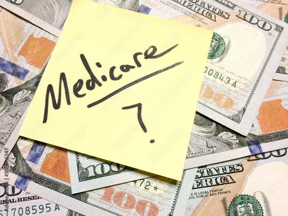 American cash money and yellow sticky note with text Medicare with ...