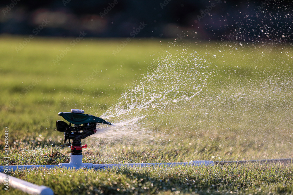 Up close photo of an automatic impact water sprinkler mounted on a ...
