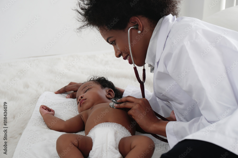 african american doctor examining black baby boy sleeping on bed with ...