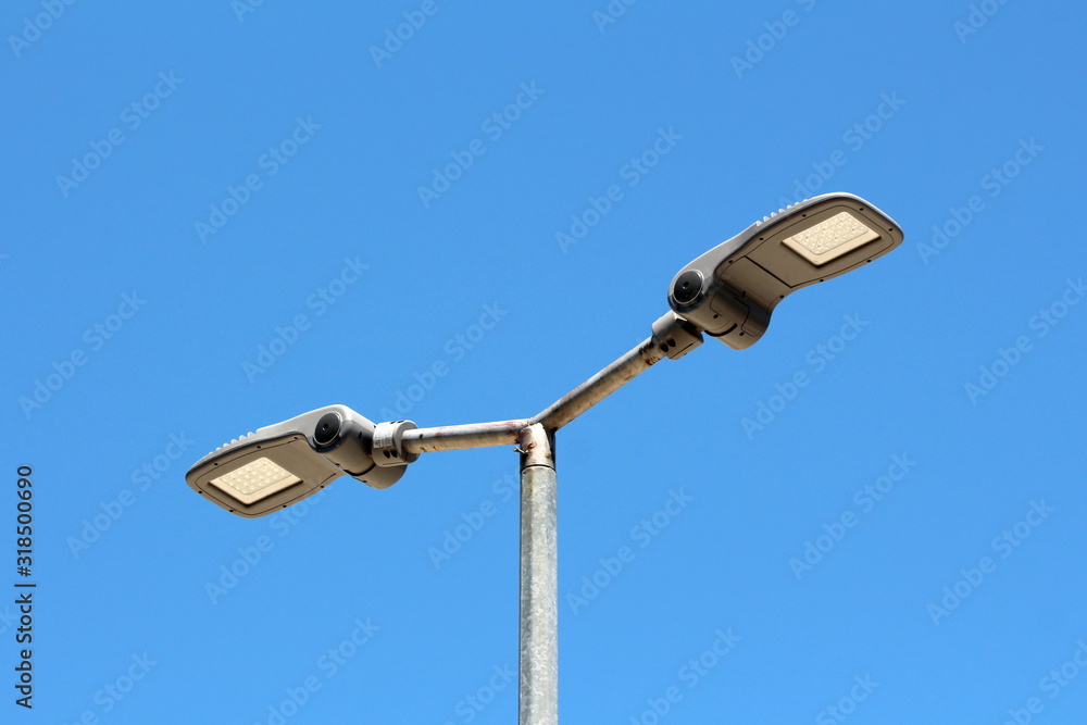 Dual modern LED street lights with adjustable angle mounted on single ...