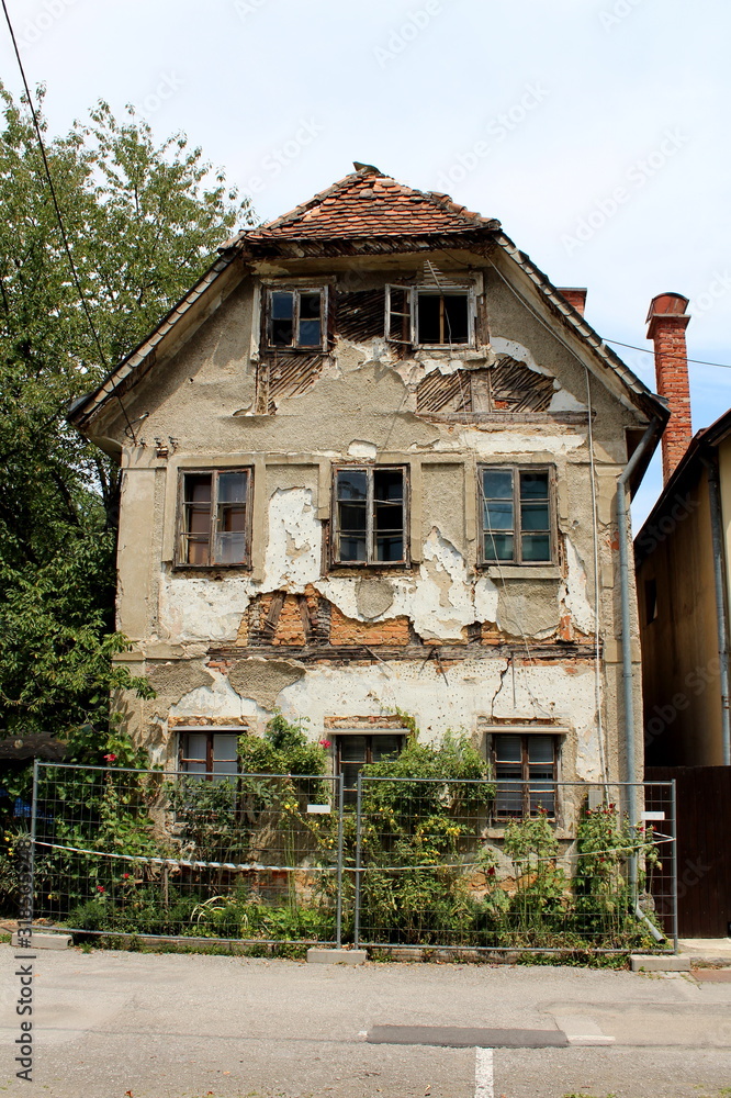 Tall narrow old abandoned suburban family house ruin with broken ...