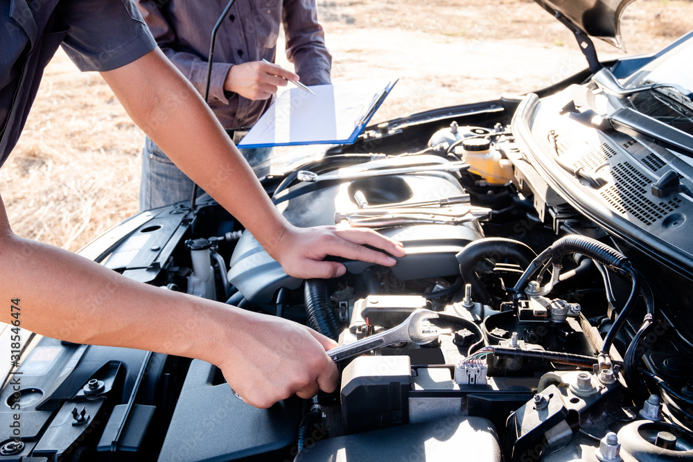 Repairman and insurance agent Checking engine order using modern tools ...